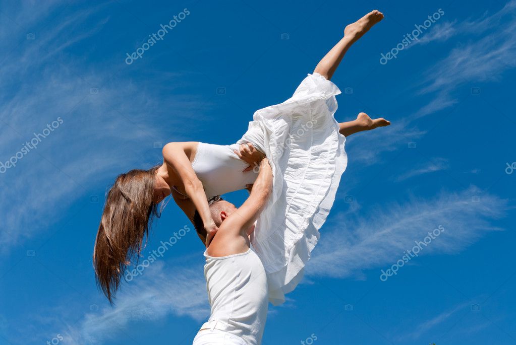 Young couple dancing on sky background, freedom and relax symbol ...