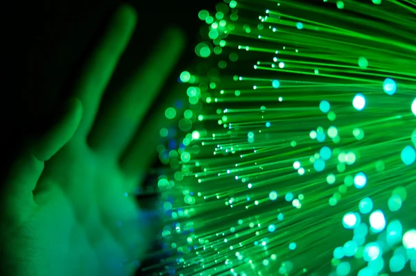 Hand touching green fiber optics - Stock Image - Everypixel