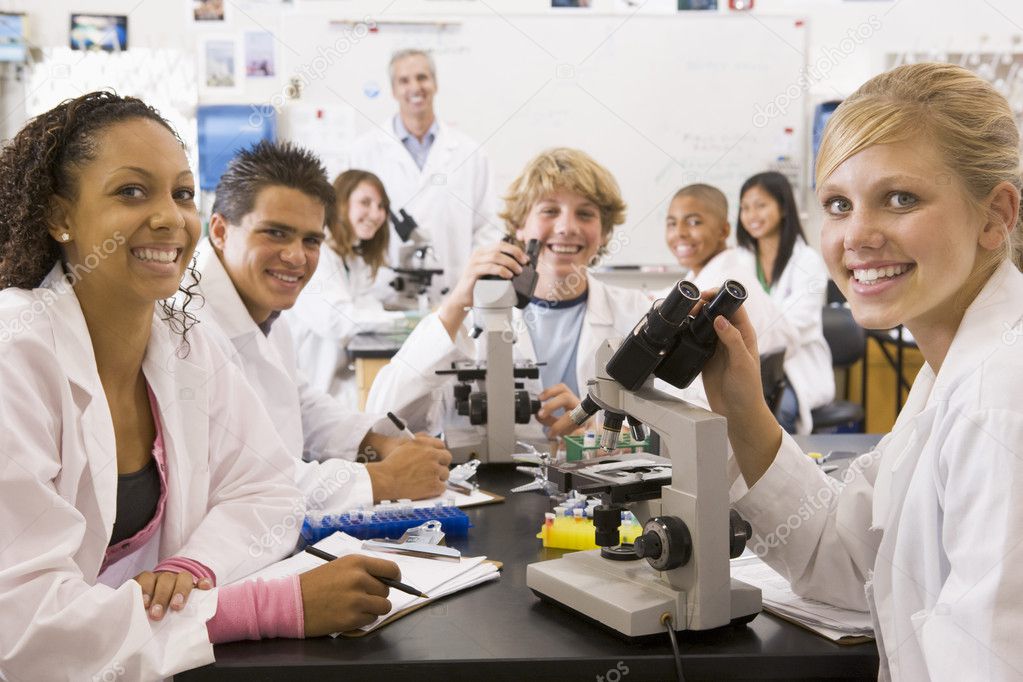 School children and their teacher in a high school science class ...